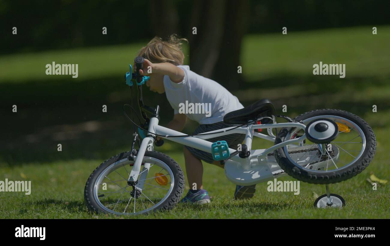 One small boy pushing bicycle falling off to ground bike falls to ...