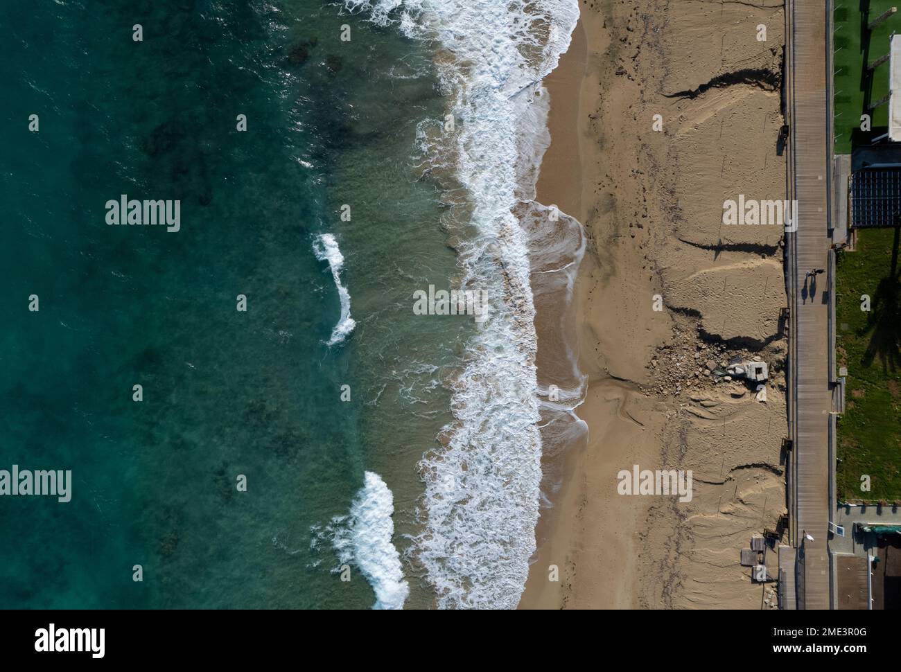 Aerial view of ocean waves breaking on a sandy beach. Beach erosion ...