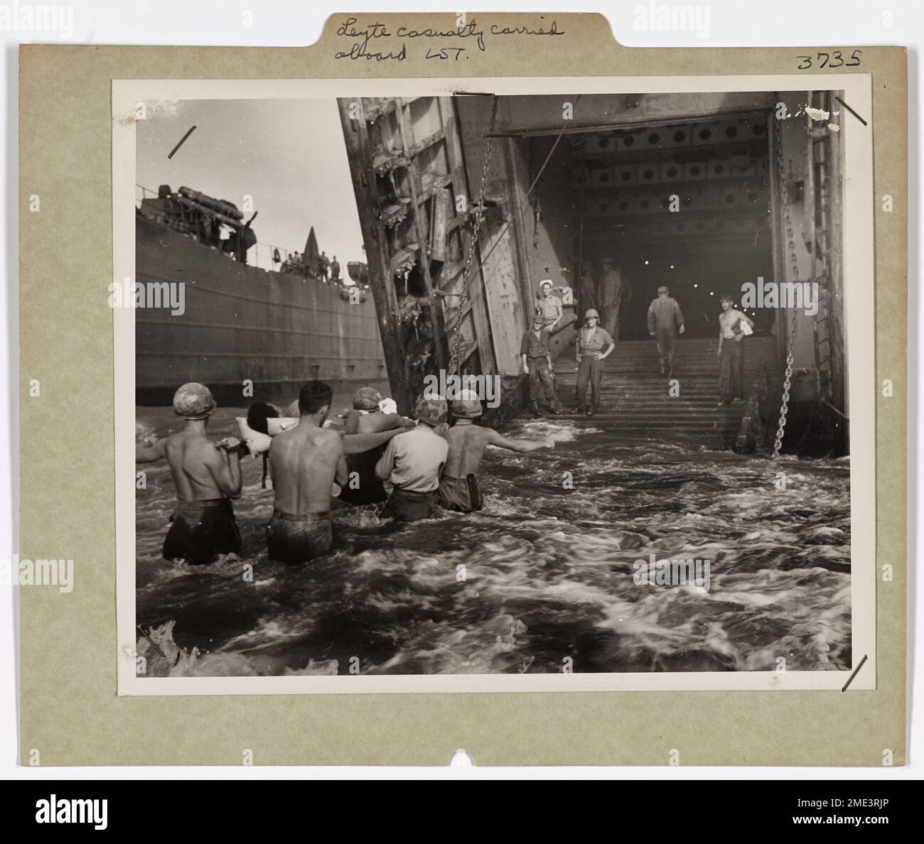 A wounded soldier is carried through the surf to a Coast Guard-manned ...