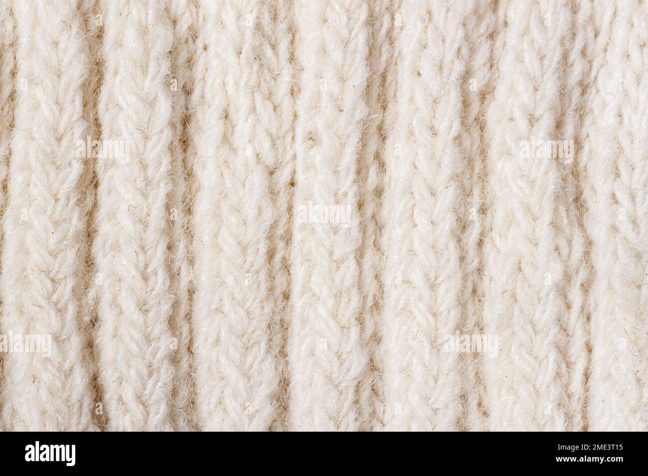 Soft knitted wool texture, warm white background, soft yarn. Loops ...