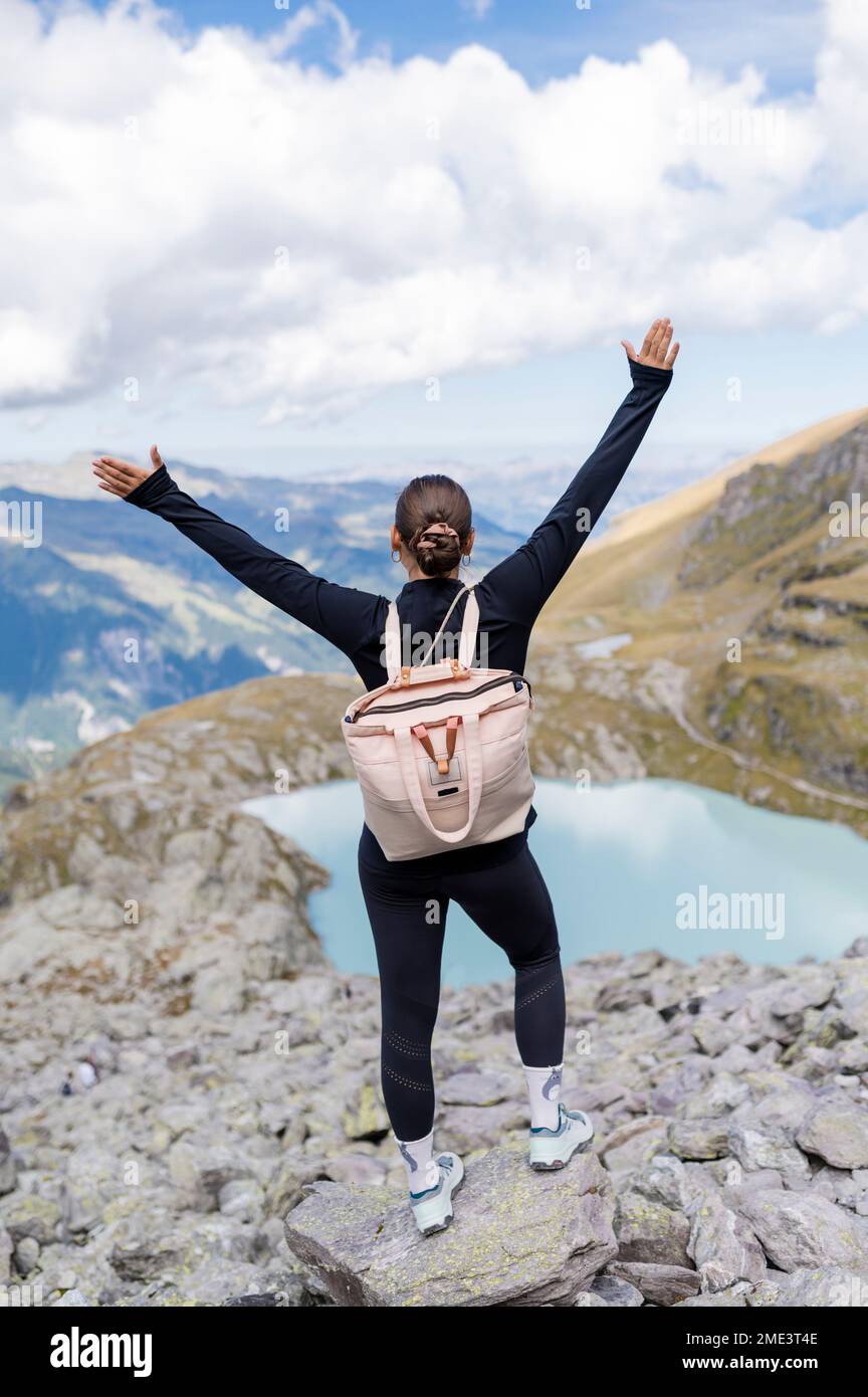 Young hiker with arms raised on rock Stock Photo - Alamy