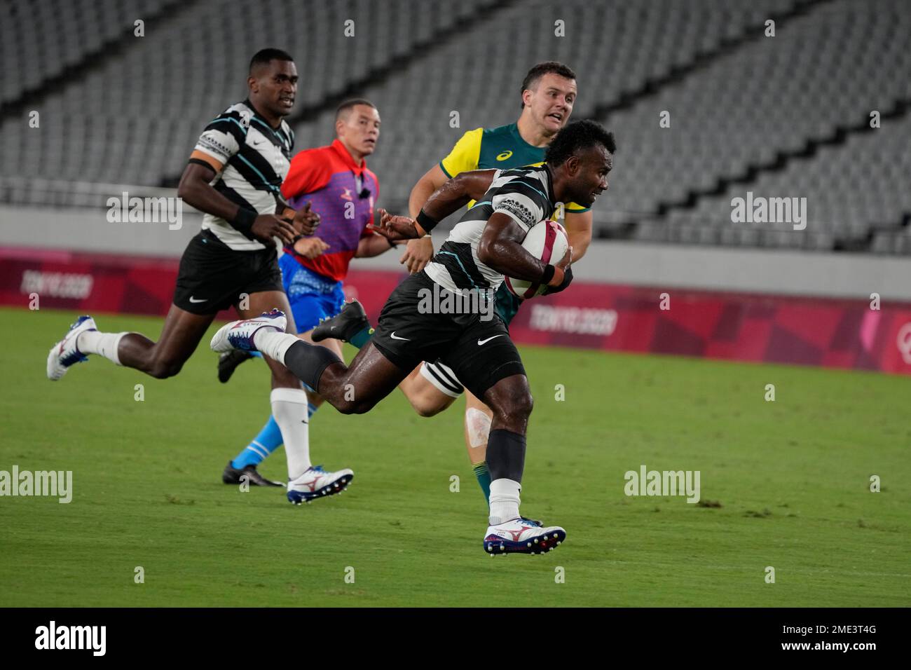 Fiji's Jerry Tuwai carries the ball past Australia's Dylan Pietsch to ...