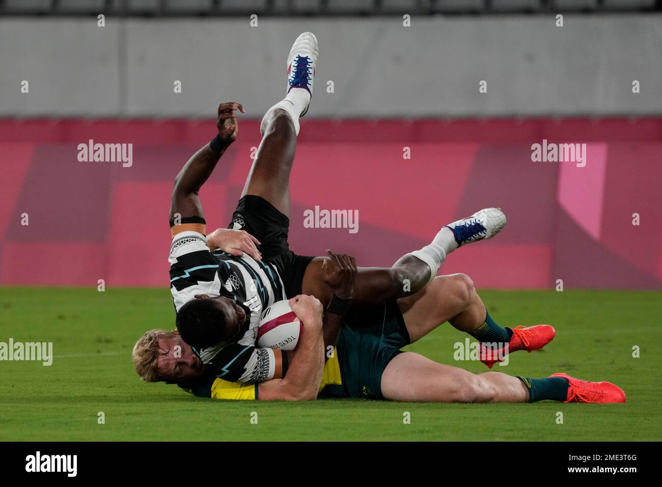 Australia's Lachie Miller, left, brings down Fiji's Aminiasi Tuimaba ...