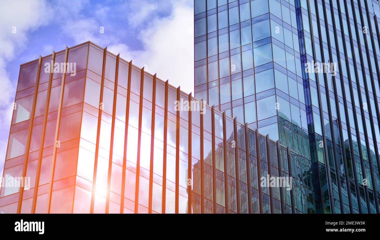 Modern glass facade against blue sky. Bottom view of a building in the ...