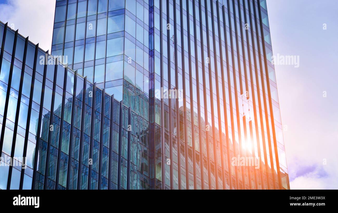 Modern glass facade against blue sky. Bottom view of a building in the ...