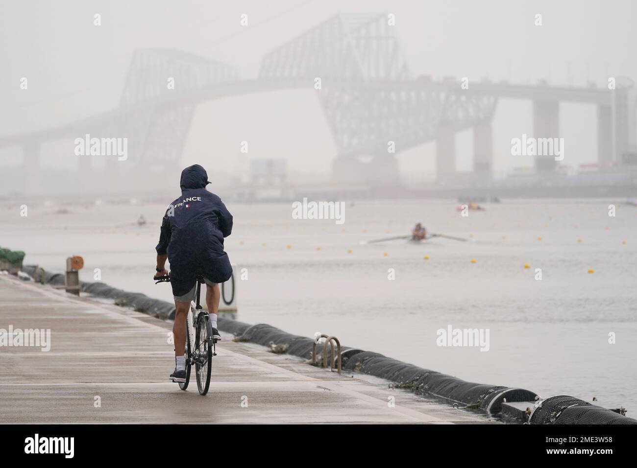 A coach from France rides her bike as rowers train during a rowing ...