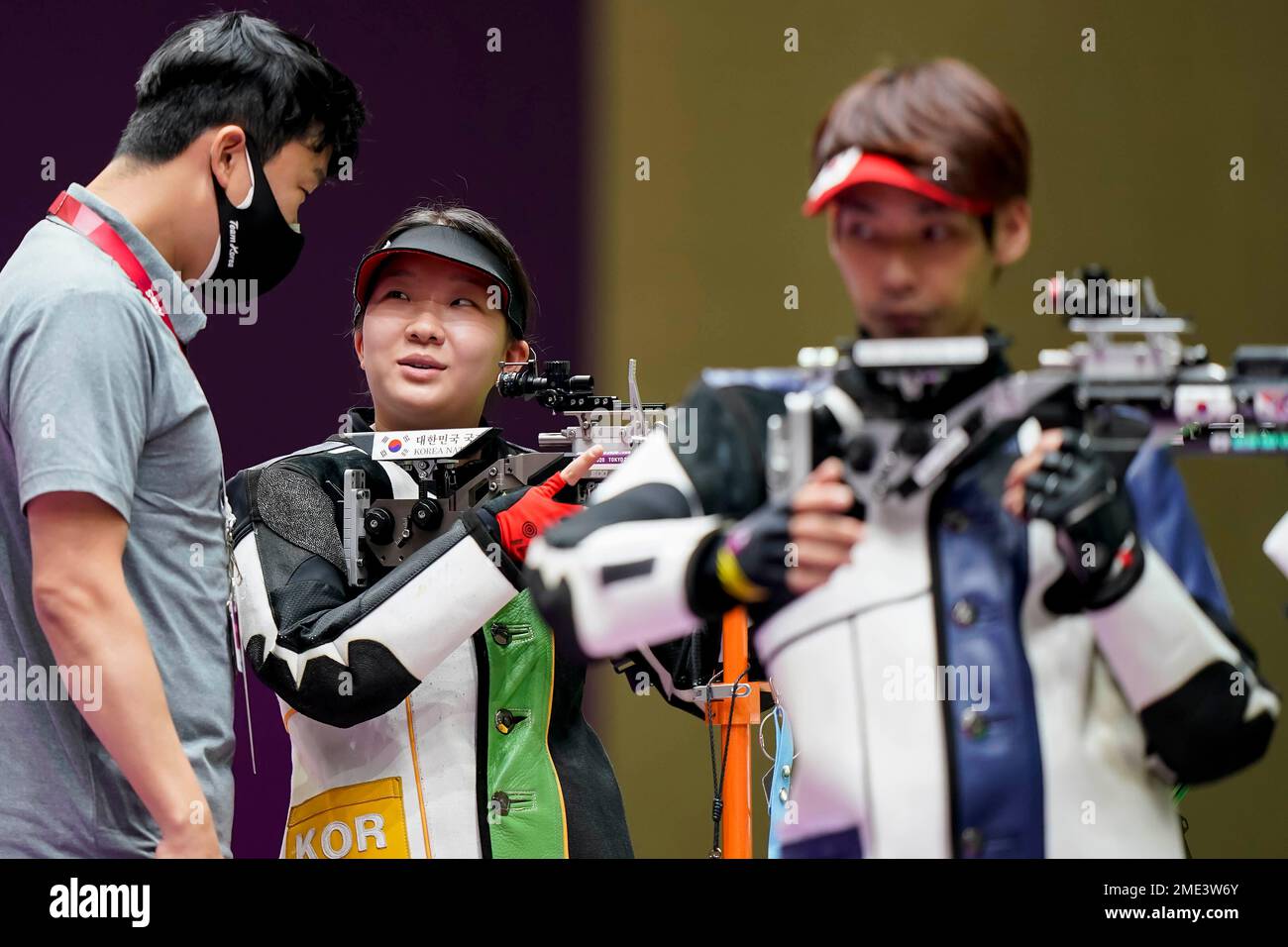 Eunji Kwon, center, and Taeyun Nam, of South Korea, listen to their coach, left, as they compete ...