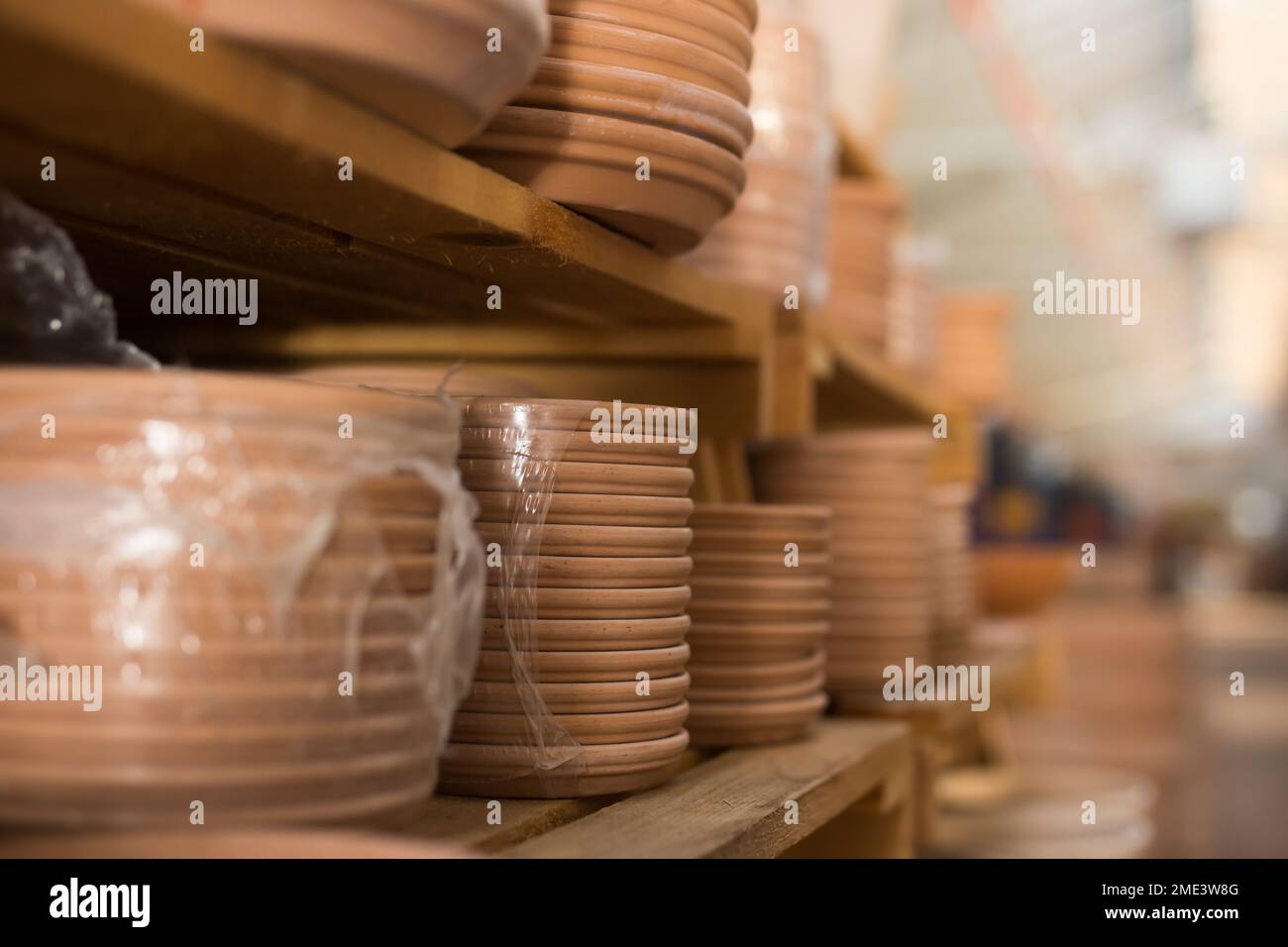 Stacks of ceramic plates for flower pots on shekves in store Stock ...