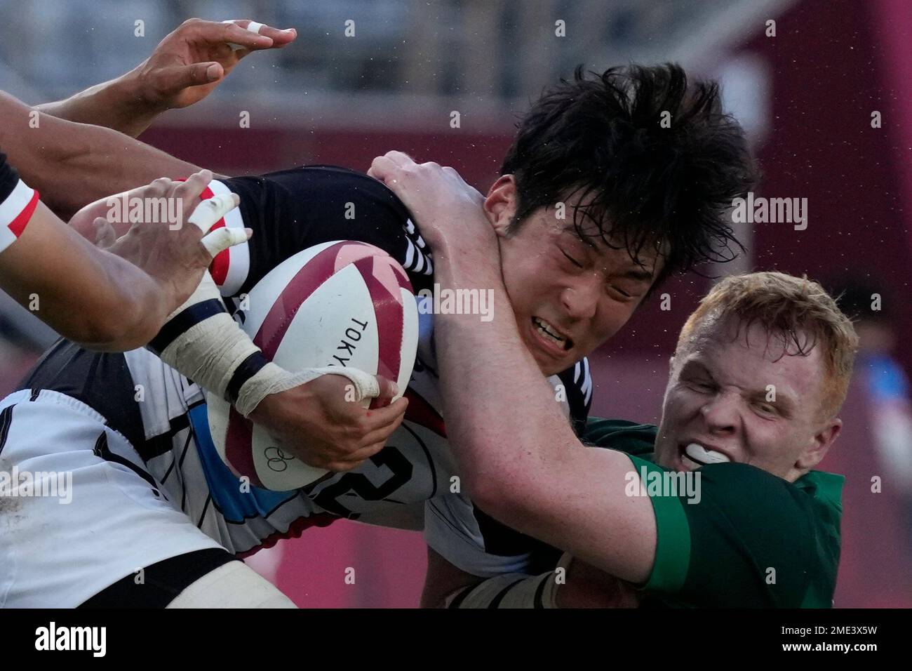 South Korea's Jeong Yeon-sik clings to the ball as he's brought down by ...