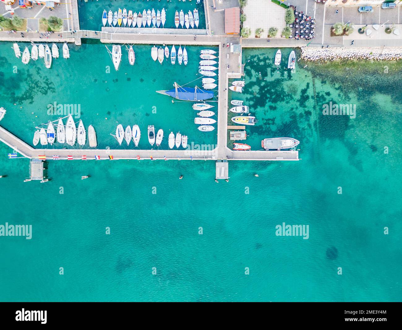 An aerial view of a port on the coast of an ocean with parked boats ...
