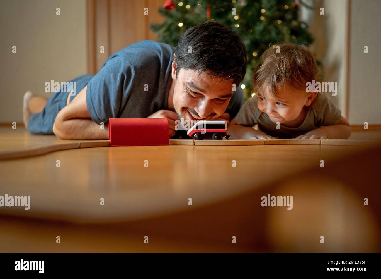 Happy father and son playing with toy train at home Stock Photo - Alamy