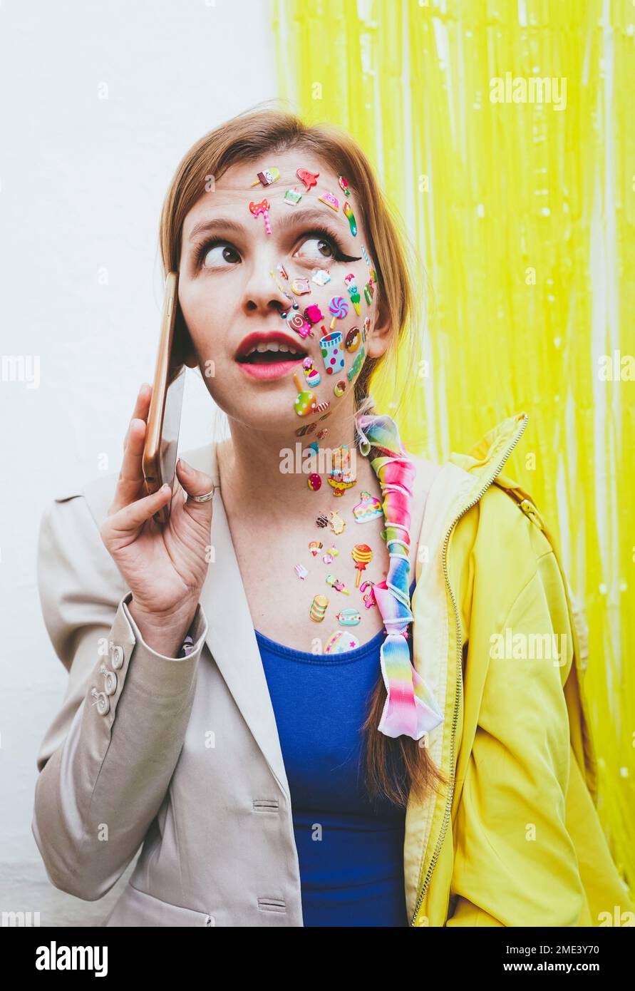 Woman with stickers on face talking through smart phone Stock Photo - Alamy