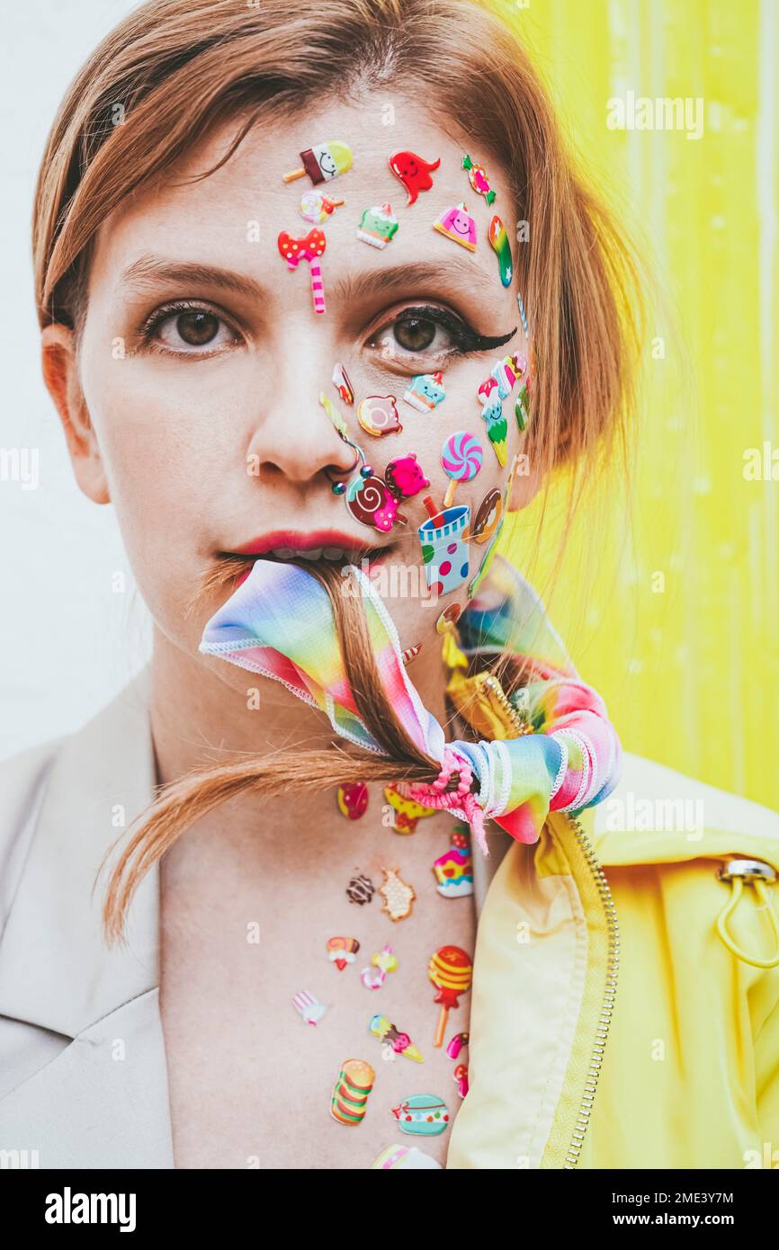Woman with stickers on face biting hair Stock Photo - Alamy