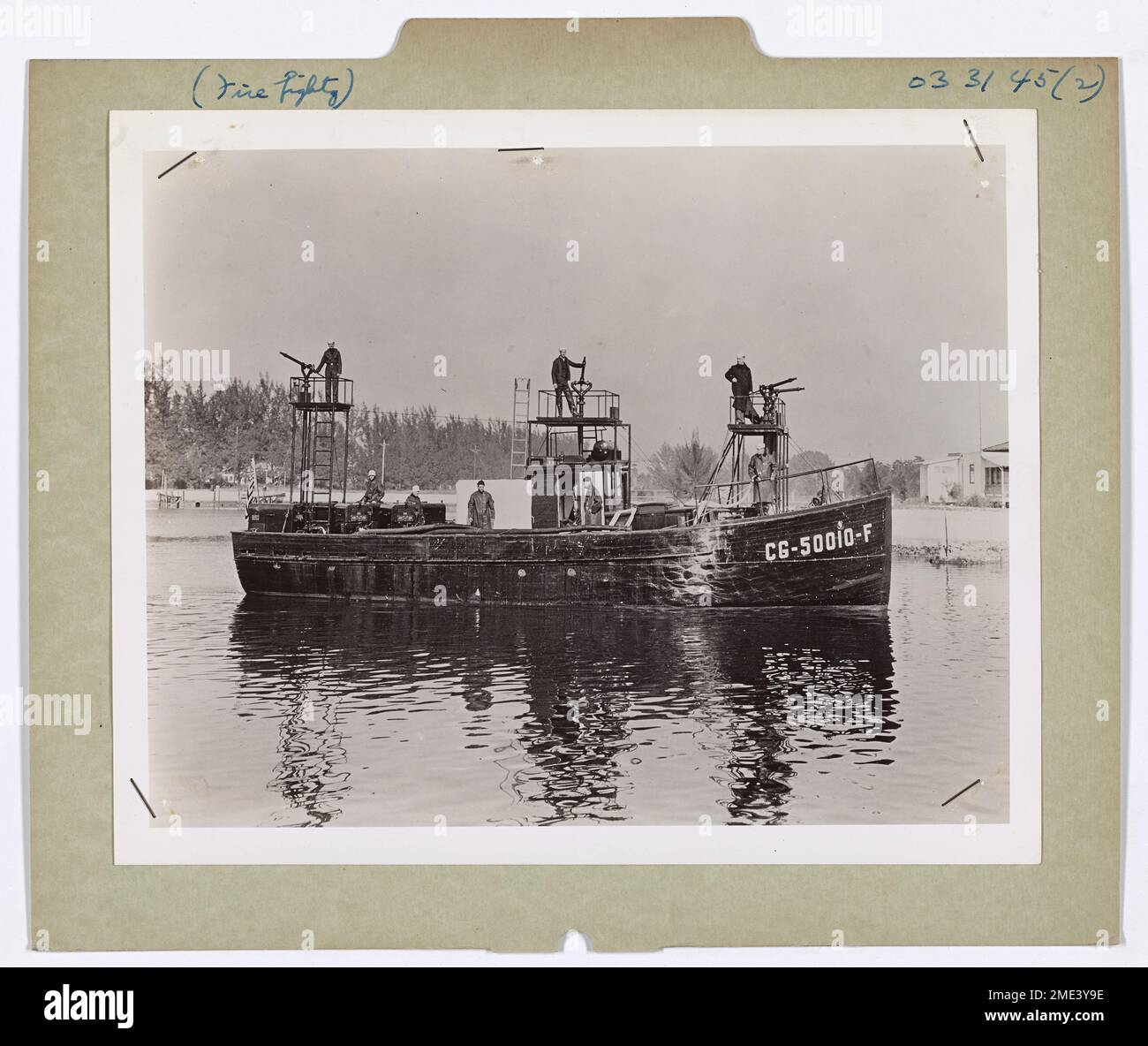 A Coast Guard team works to control a fire on a vessel or dock ...