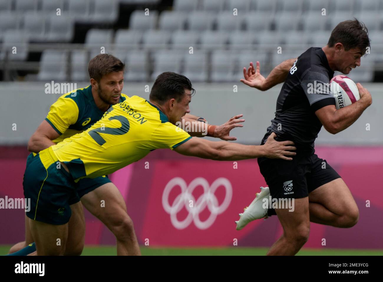 New Zealand's Andrew Knewstubb, right, evades a tackle by Australia's ...