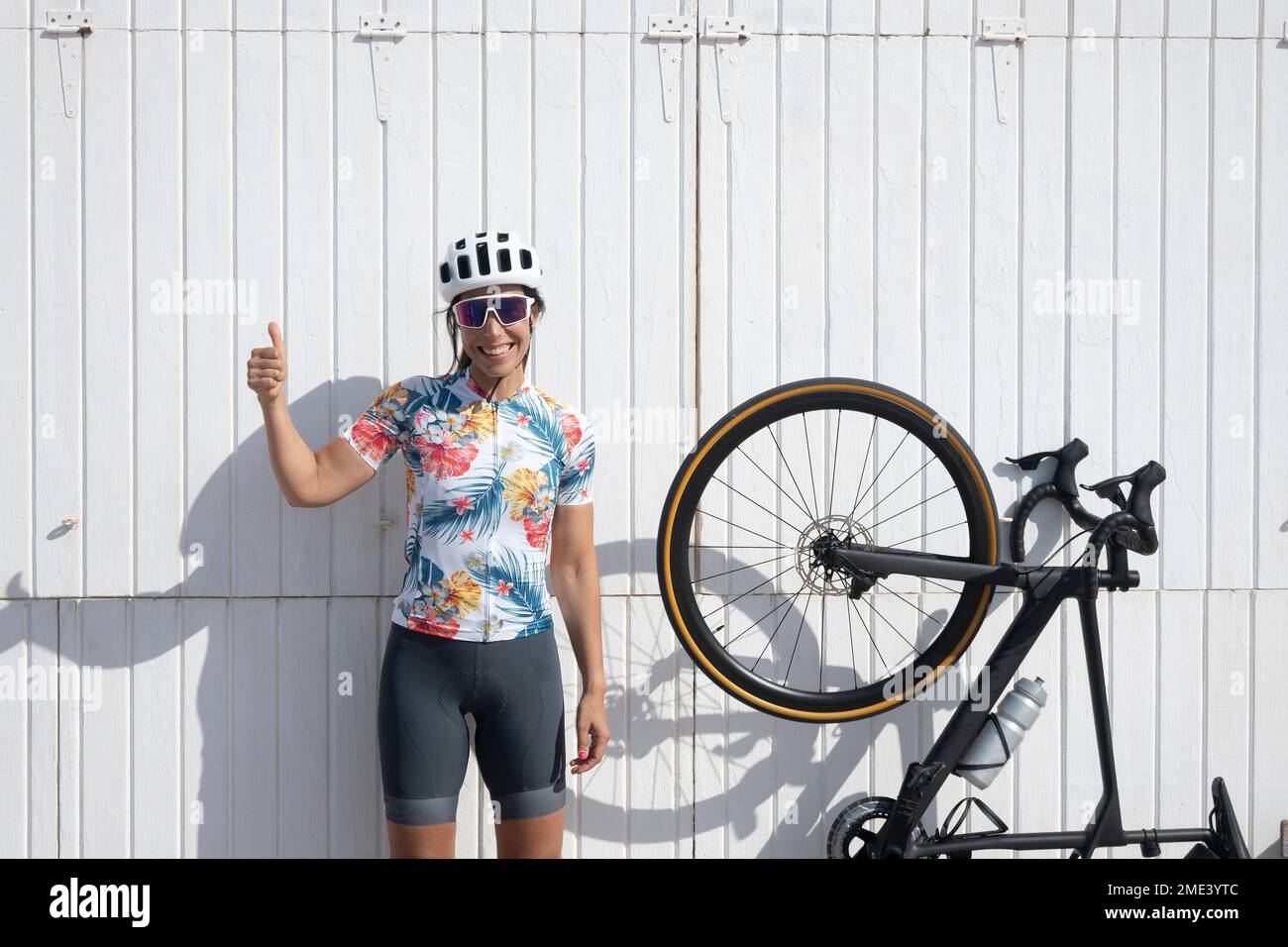 Happy cyclist showing thumbs up gesture standing in front of wall Stock ...
