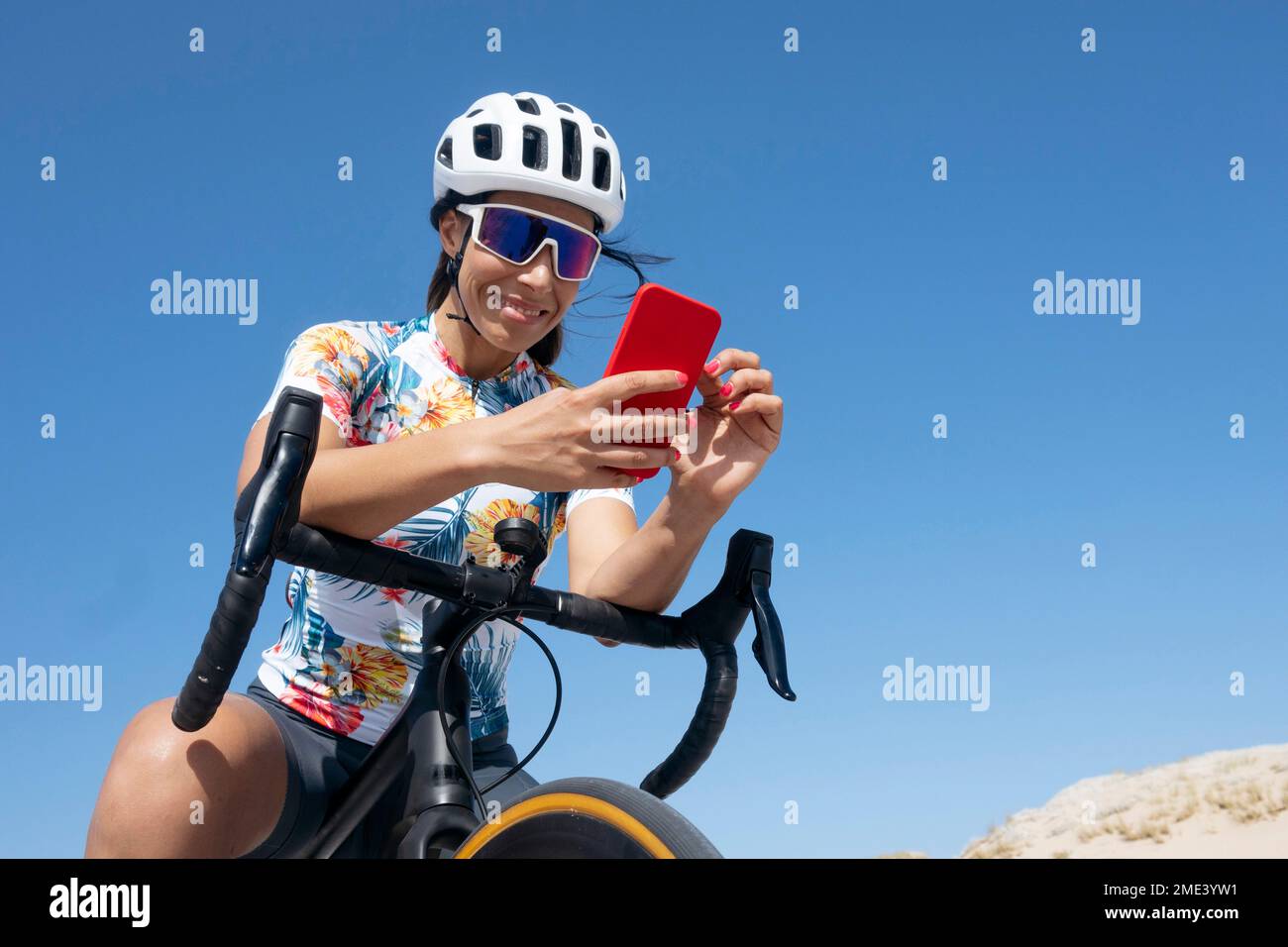 Happy cyclist using smart phone sitting on bicycle Stock Photo - Alamy