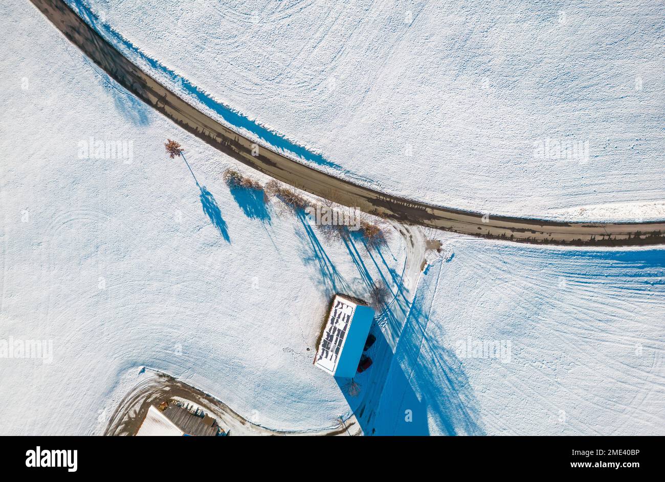 An aerial view of a road with a landscape covered with snow on each ...