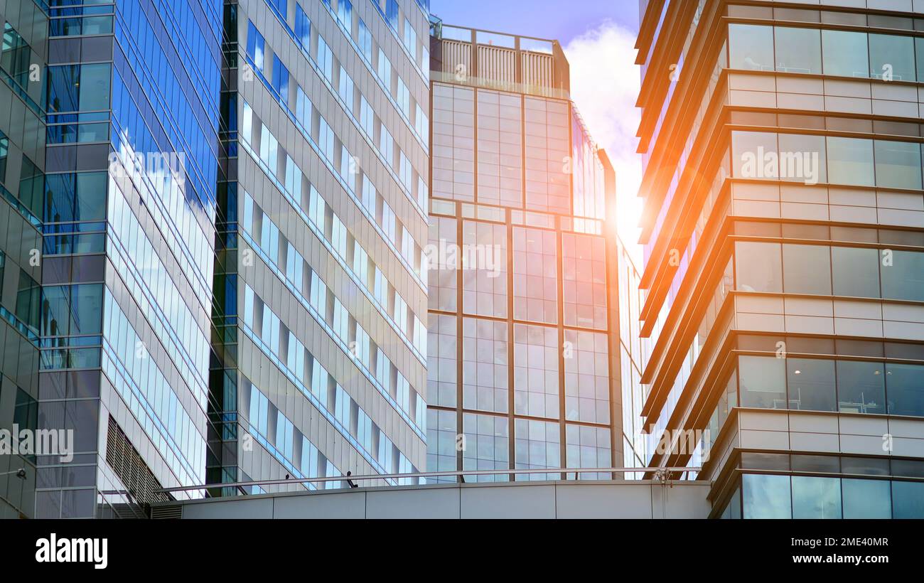 Modern glass facade against blue sky. Bottom view of a building in the ...