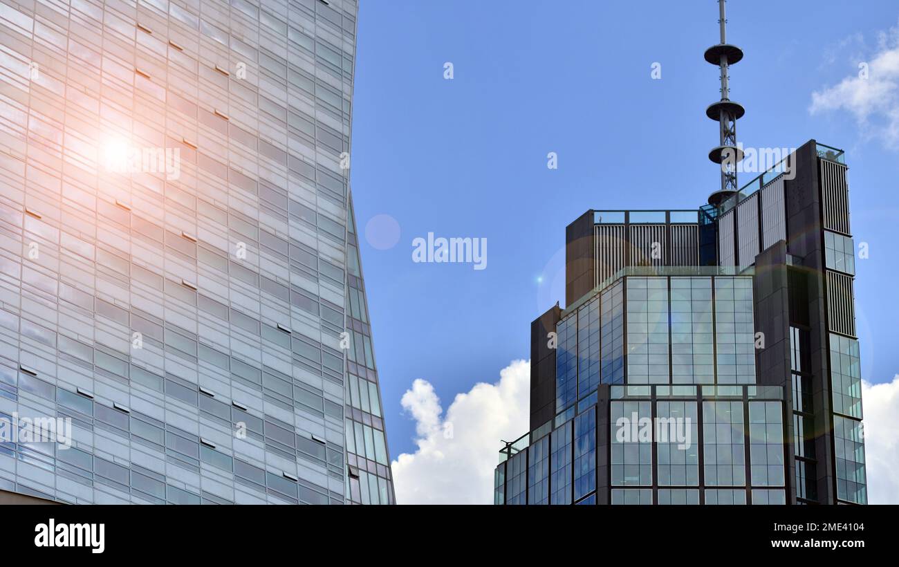 Modern glass facade against blue sky. Bottom view of a building in the ...
