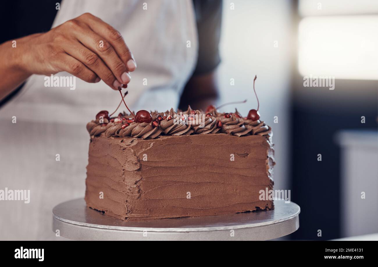 Hand, cake and food with a man chef working in a kitchen while ...