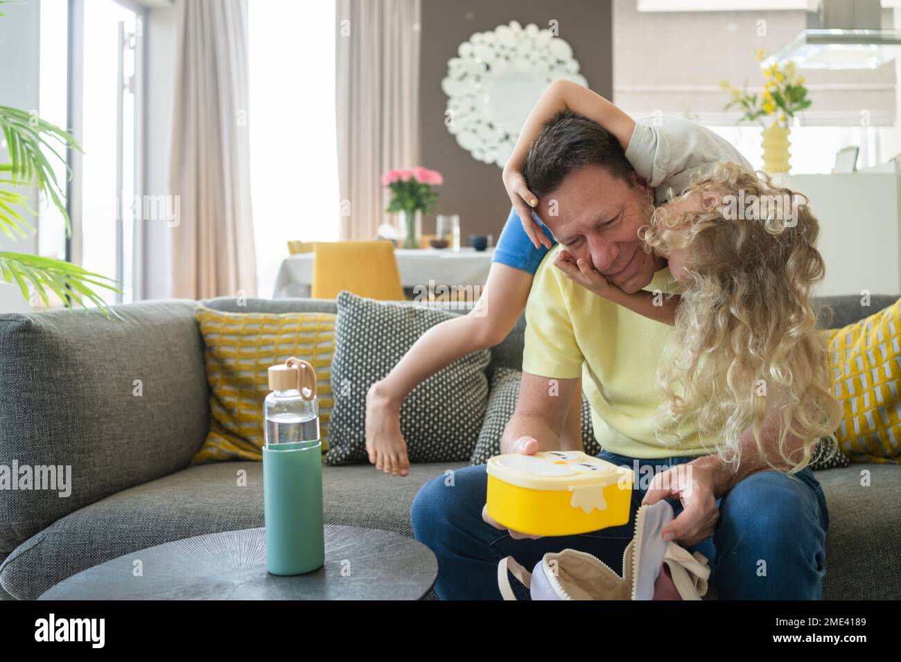Father holding lunch box with playful daughter at home Stock Photo - Alamy