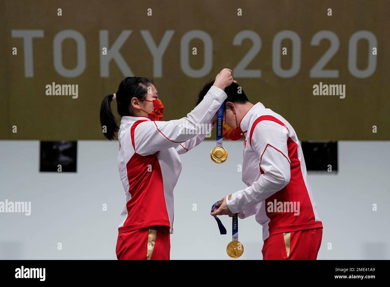 Jiang Ranxin, left, places the gold medal on her teammate Pang Wei, of ...