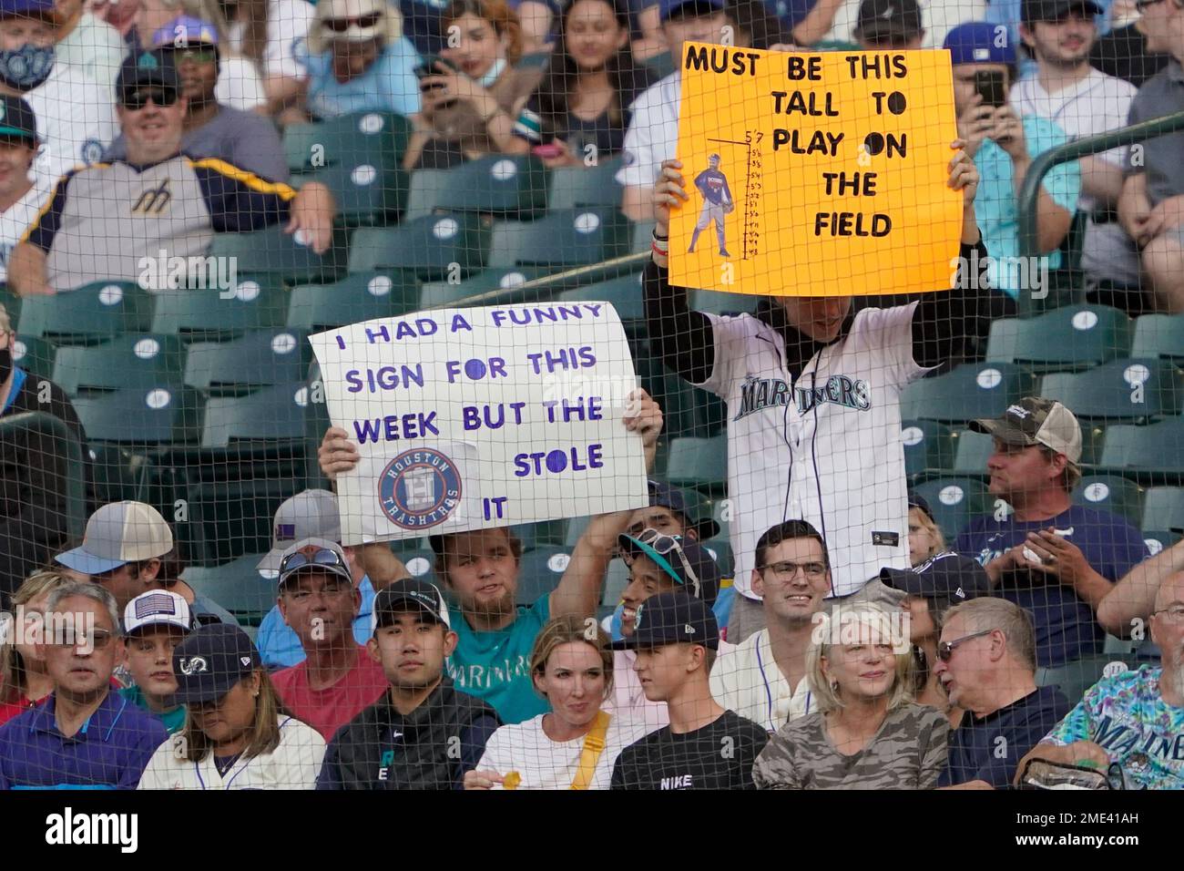 Seattle Mariners fans hold signs mocking the height of Houston Astros ...