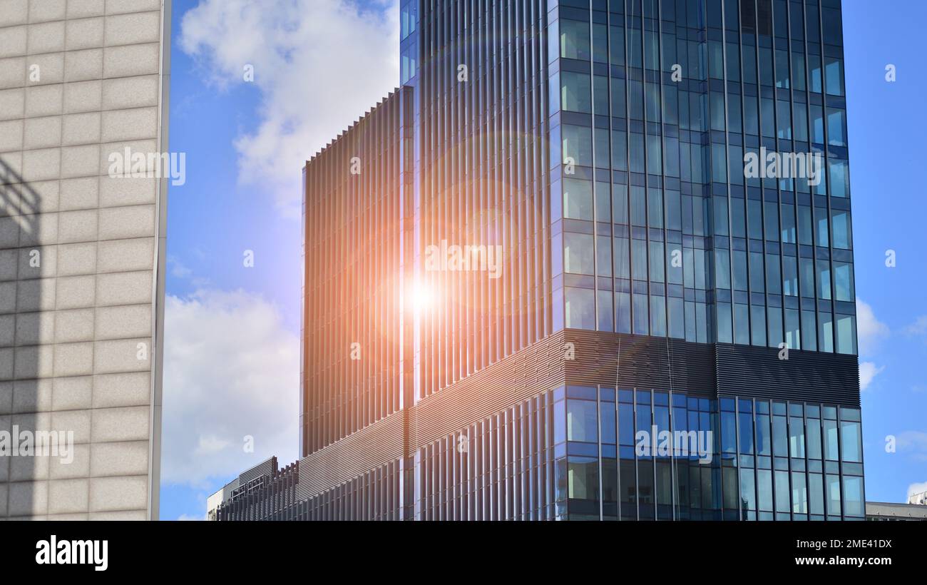 Modern glass facade against blue sky. Bottom view of a building in the ...