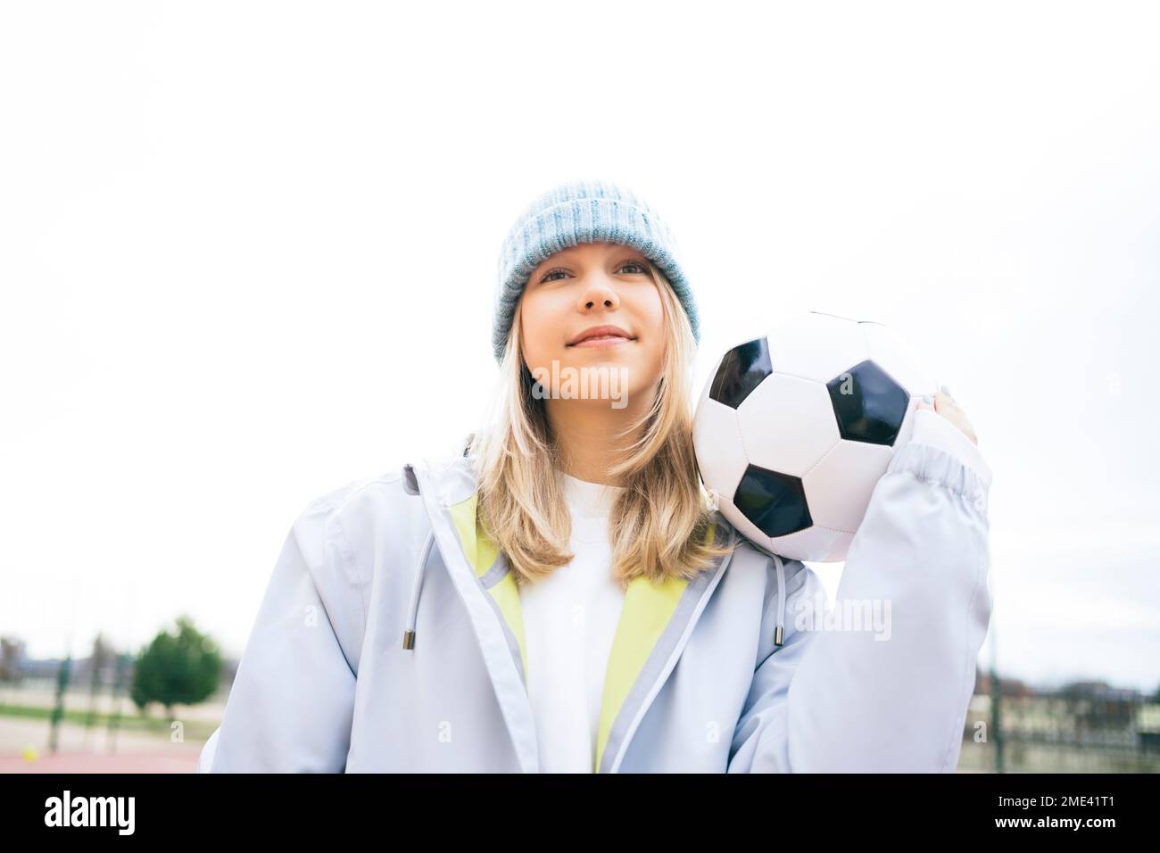 Girl standing with soccer ball under clear sky Stock Photo - Alamy