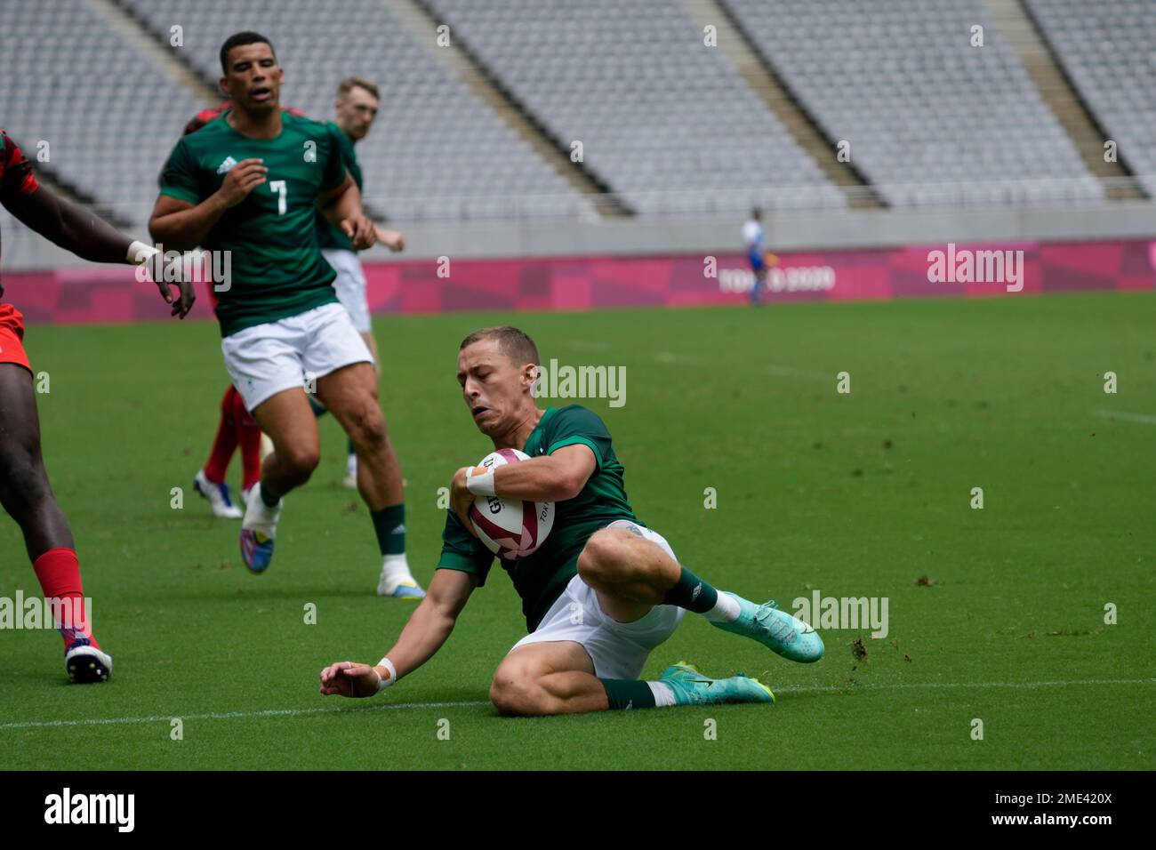Ireland's Hugo Lennox scores a try as Ireland's Jordan Conroy looks on ...