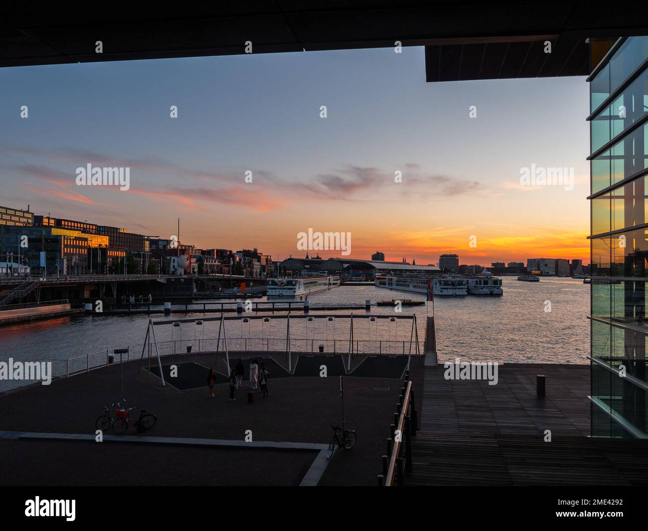 A scenic view of modern buildings on the coast of an ocean with boats ...