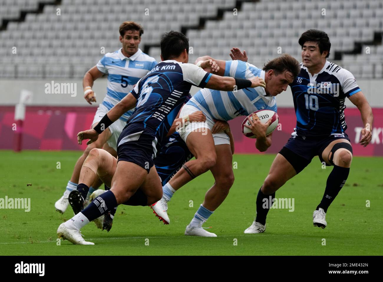 Argentina's Luciano Gonzalez, center, powers through South Korean ...
