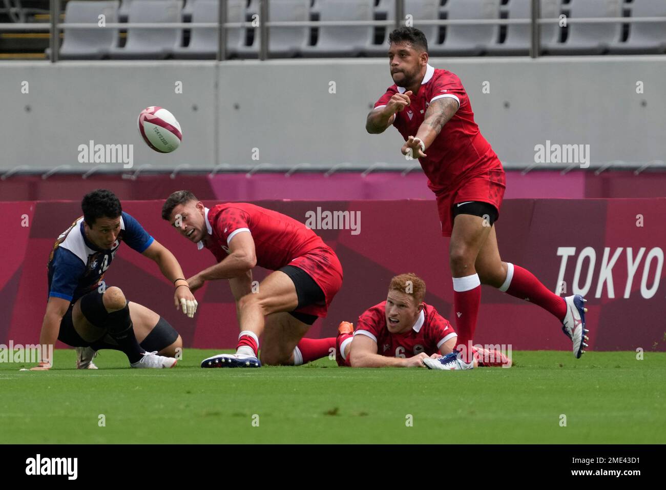 Canada's Mike Fuailefau, right, passes the ball as Canada's Connor ...