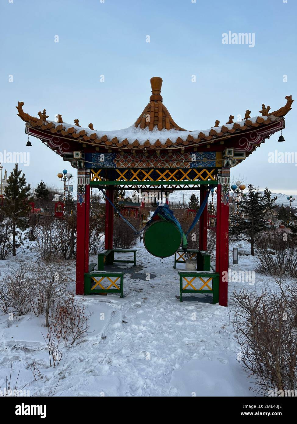 A vertical shot of a traditional Asian pavilion temple with snow on the ...