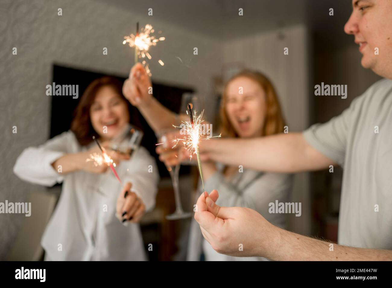 Cheerful friends having fun with sparklers at home Stock Photo - Alamy