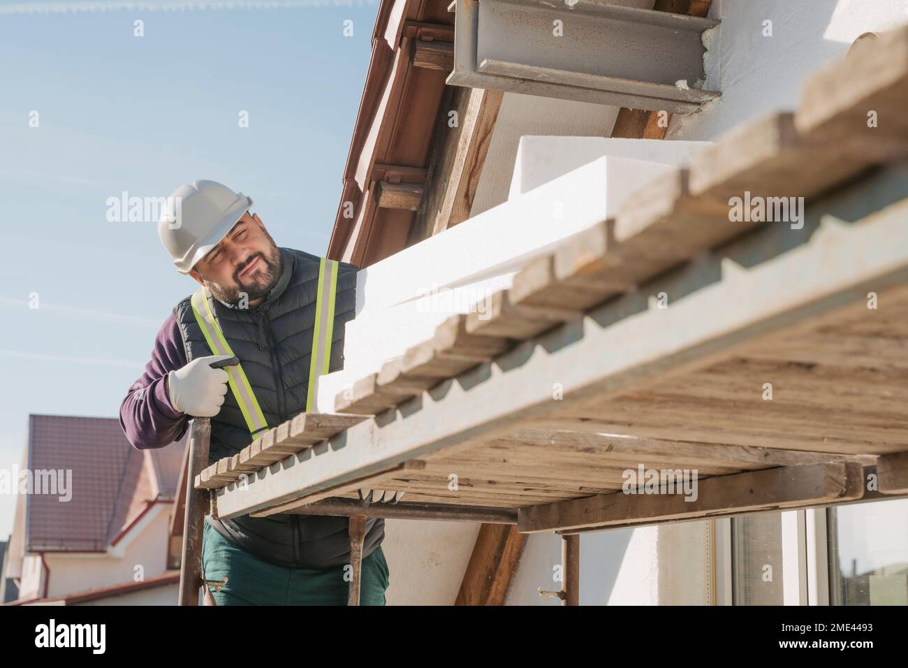Construction worker with polystyrene foam working at site Stock Photo ...