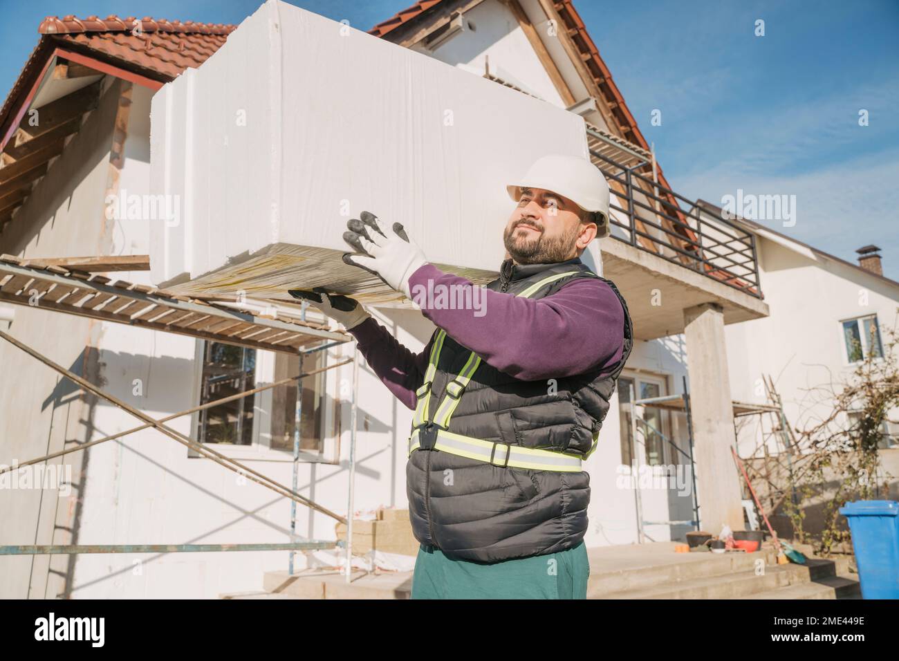 Construction worker walking with polystyrene foam on sunny day Stock ...