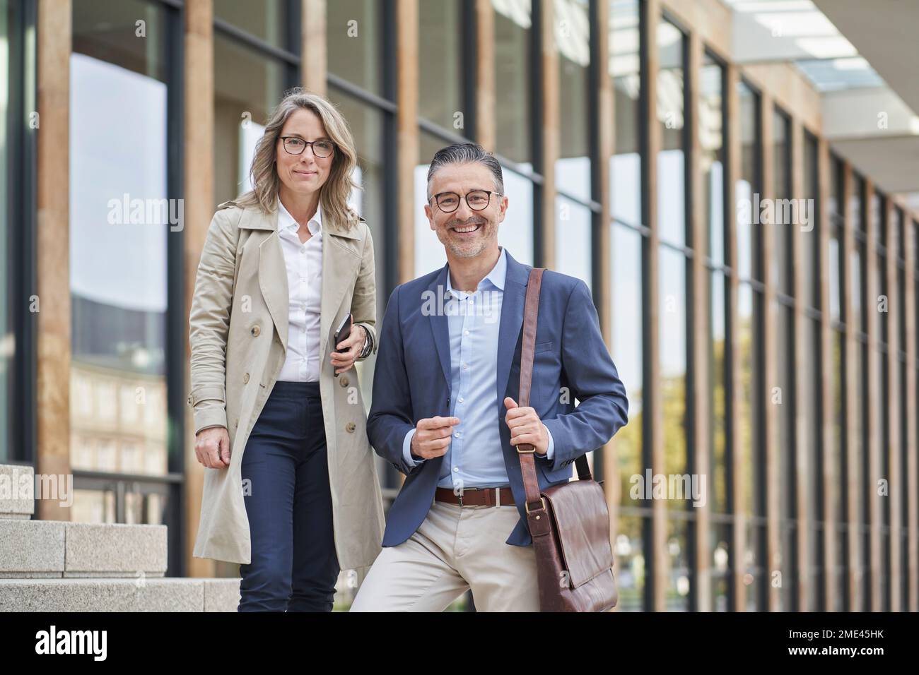 Mature business people standing outside building Stock Photo - Alamy