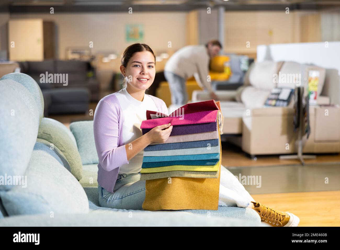 Female furniture salesperson showing different fabric samples in ...