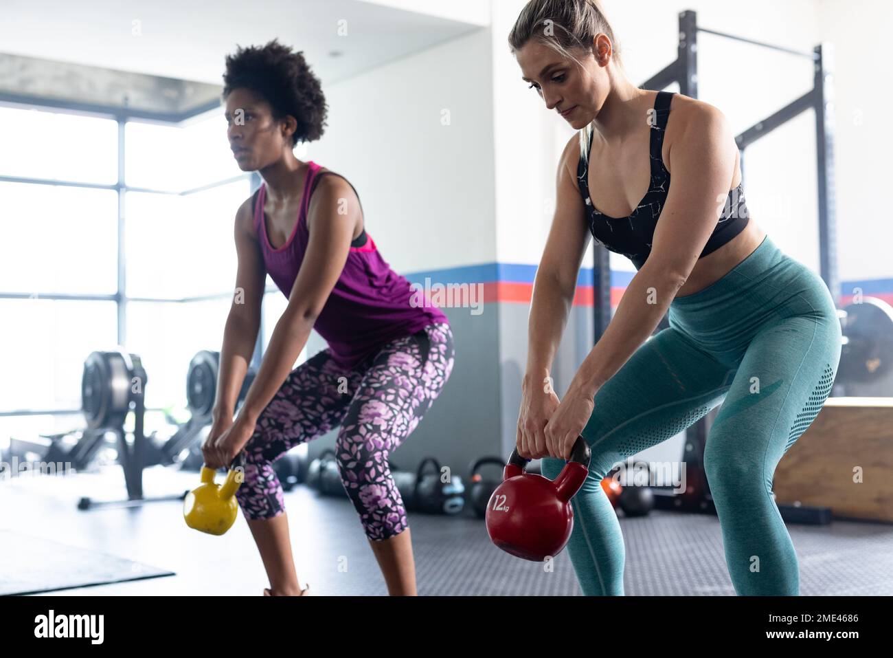Diverse fit women exercising and using kettlebells at a gym Stock Photo ...