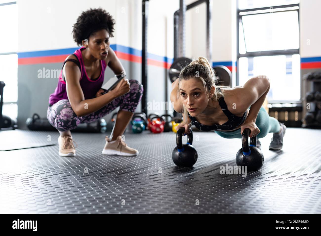 Diverse fit women exercising and using kettlebells at a gym Stock Photo ...