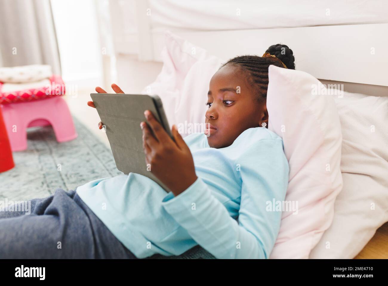 African american girl sitting on floor and using tablet Stock Photo - Alamy