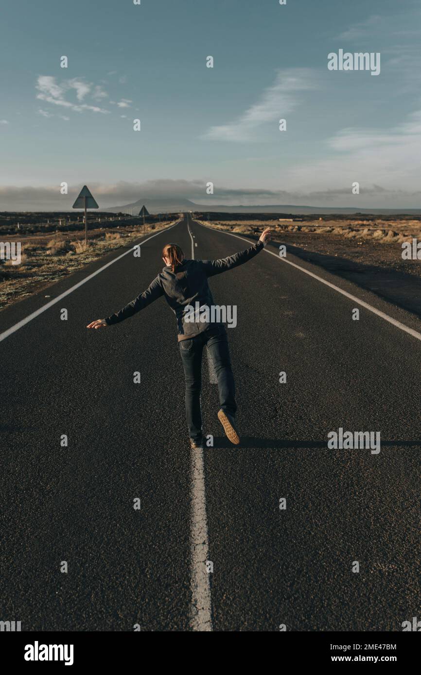 Woman standing on one leg in middle of road Stock Photo - Alamy