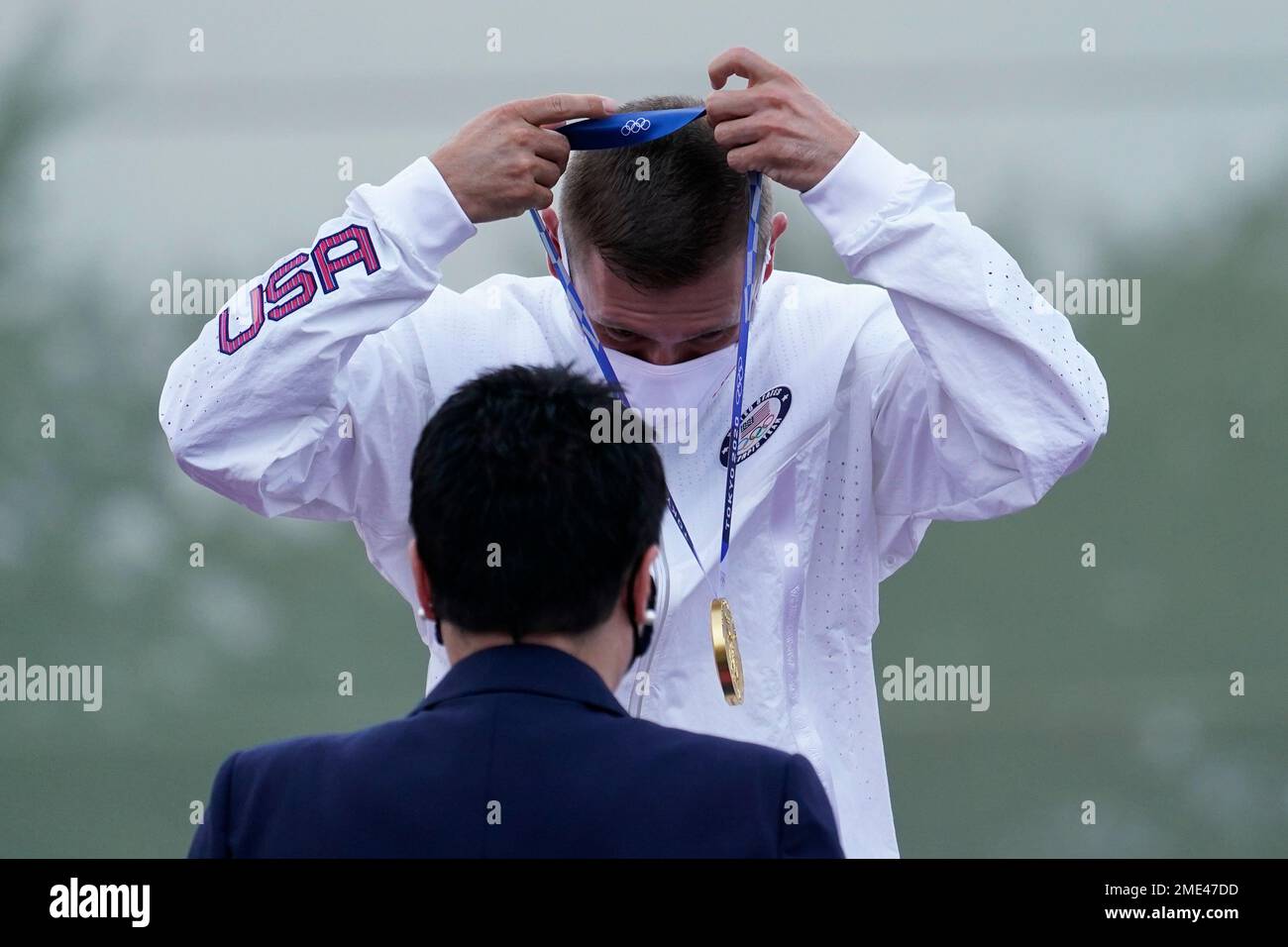Vincent Hancock, of the United States, puts on his gold medal after the ...
