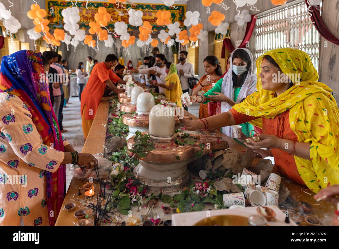 Indian Hindu devotees offer prayers before a row of Shivlings, idols ...