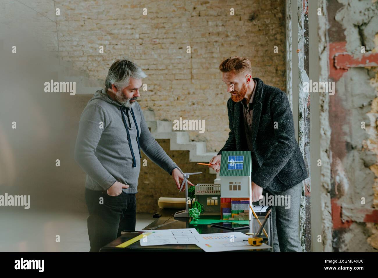 Customer having discussion with architect over model house at ...