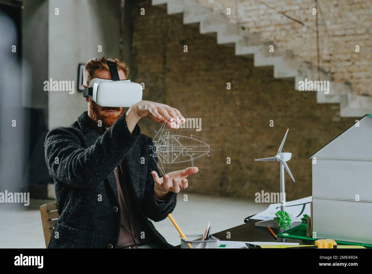 Architect wearing VR simulator gesturing with wind turbine design at ...