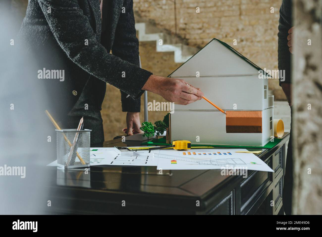 Architect showing insulation on model house on desk at construction ...