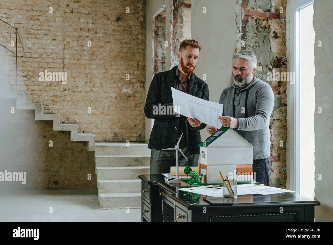 Architect showing blueprint to customer at construction site Stock ...